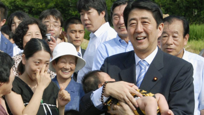 abe-shinzo-holding-a-baby - GirlTalkHQ